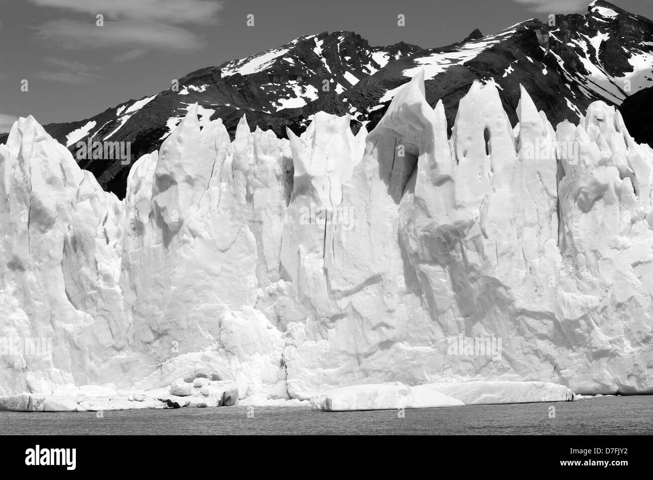 An iceberg cliff on the water and a mountain in the background Stock ...