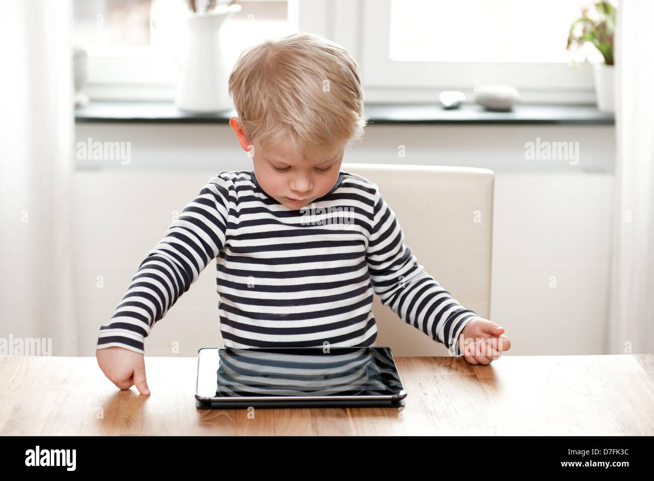 A little boy is watching something on the ipad Stock Photo - Alamy