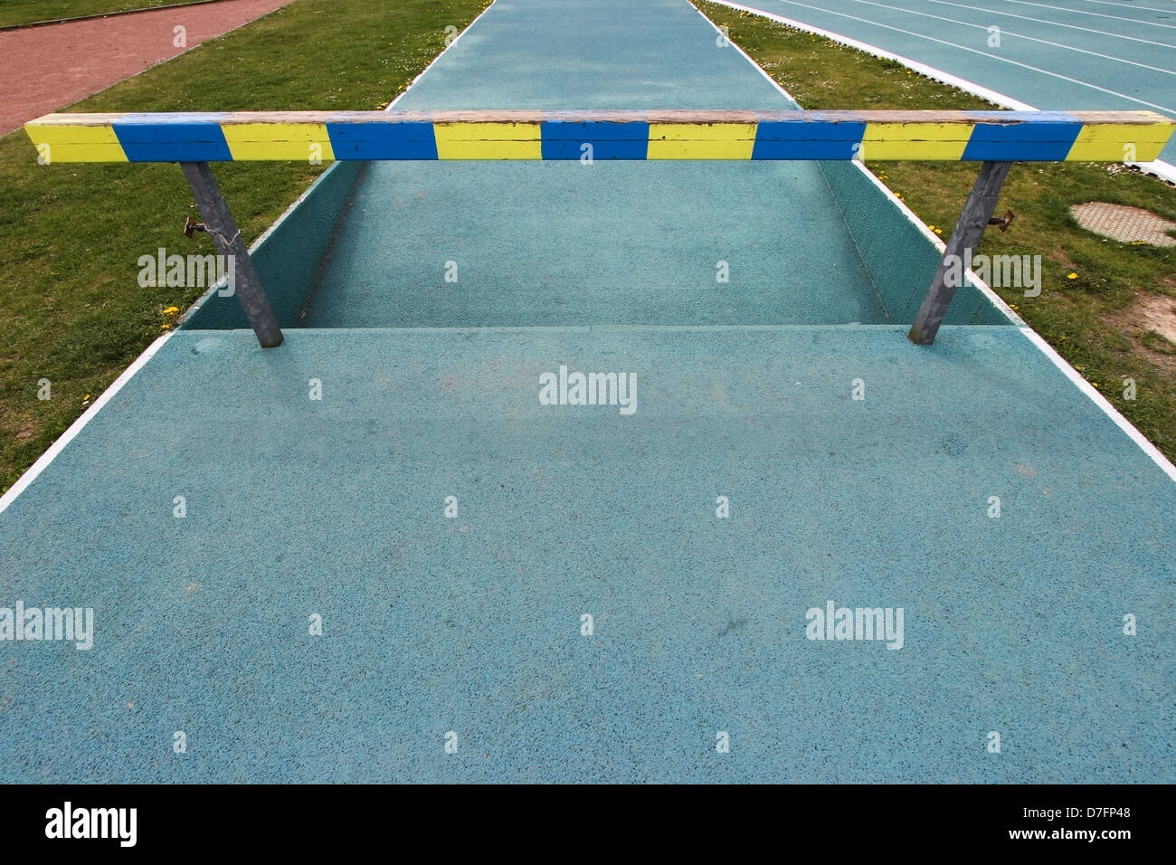 jumping obstacle on a running racetrack with white lines on blue ground ...