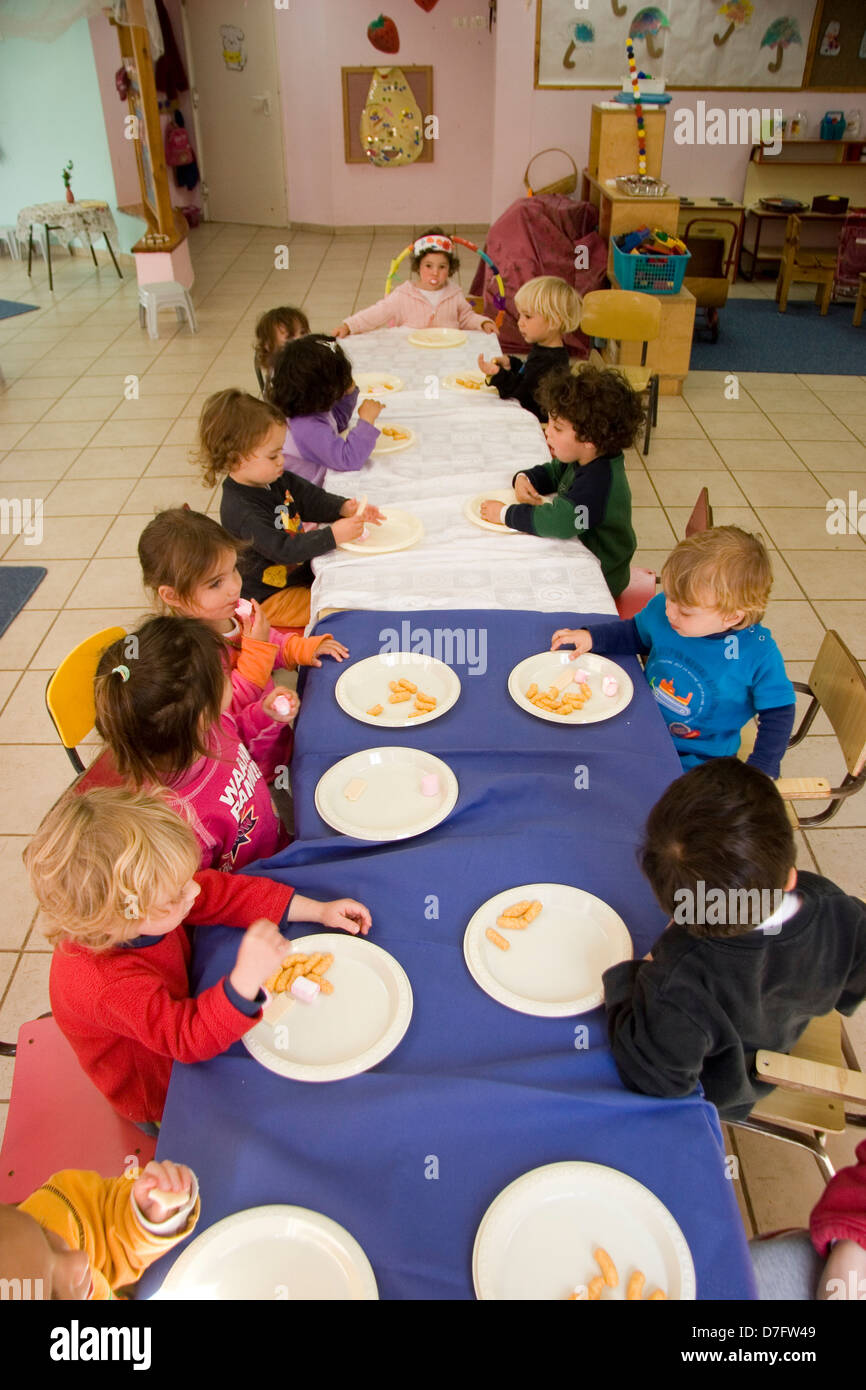 children sitting by a table at kindergarten Stock Photo - Alamy