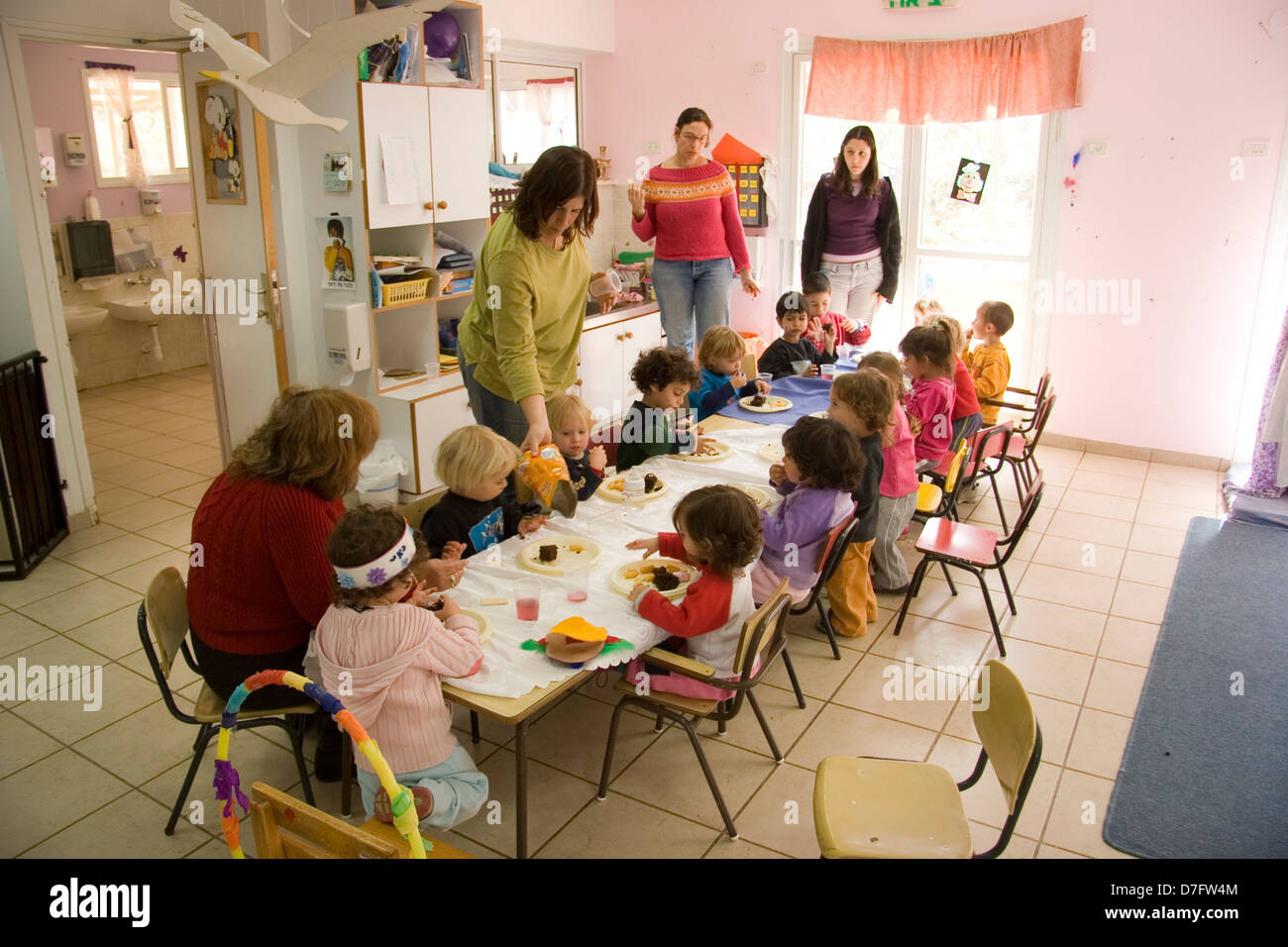 children sitting by a table at kindergarten Stock Photo - Alamy