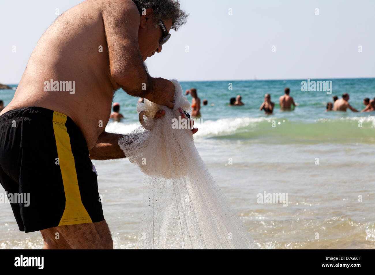Tel-Aviv, Israel - August 18th, 2012: A mature man pulling a fishing ...