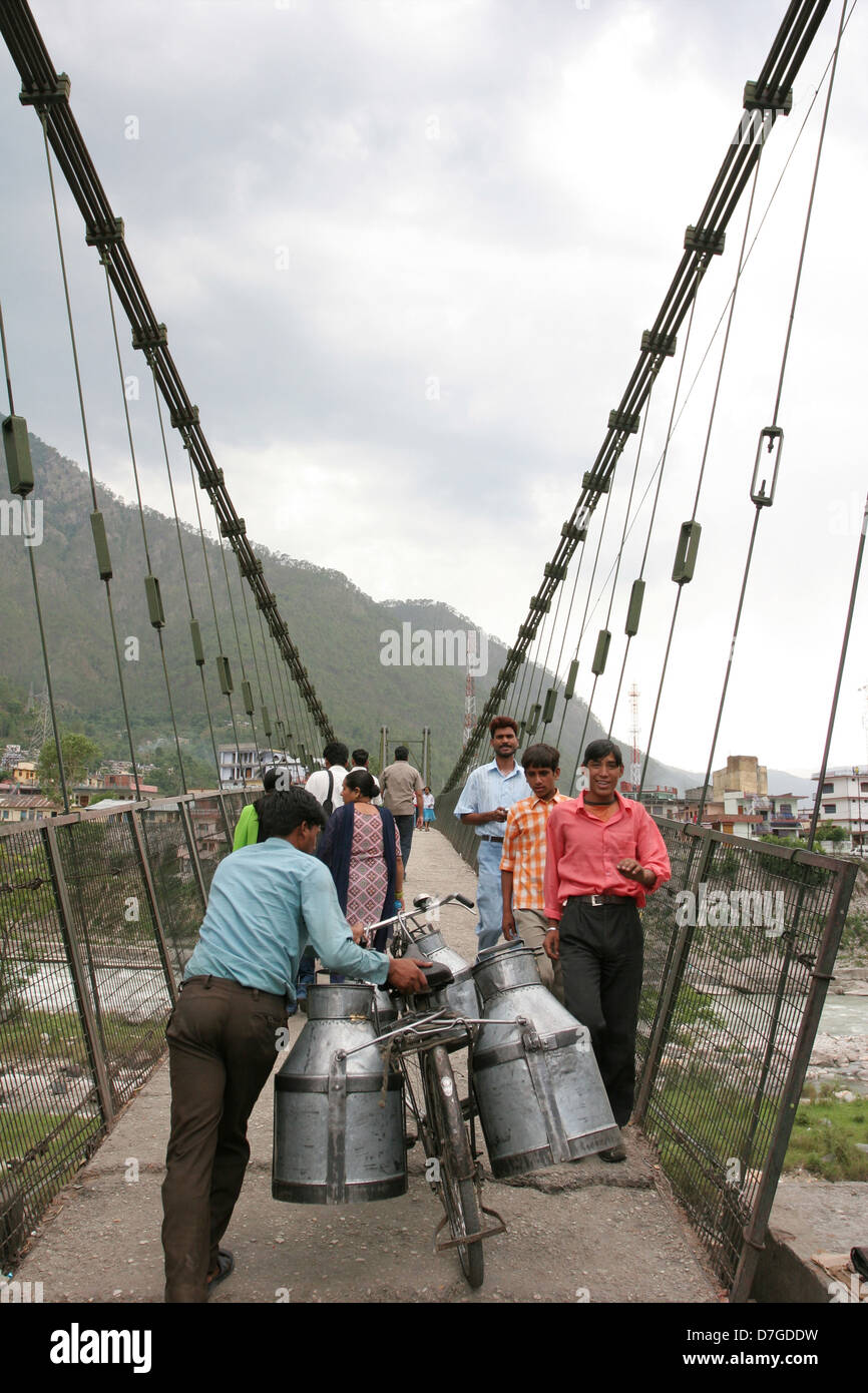 The milk man crosses the suspension bridge above the Bhagirathi River ...
