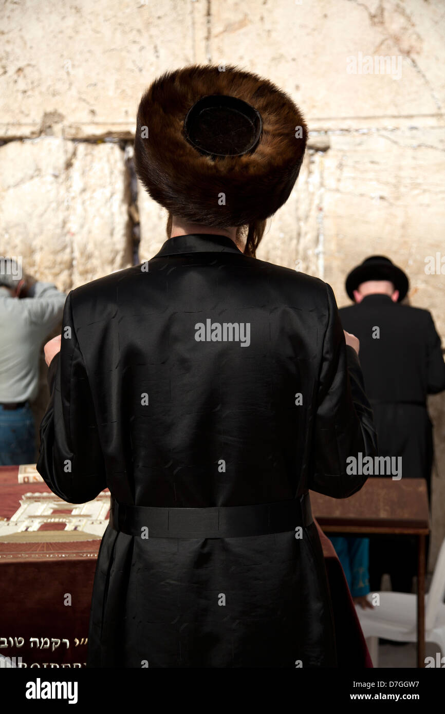 An orthodox Jewish young adult standing in prayerin front of the ...