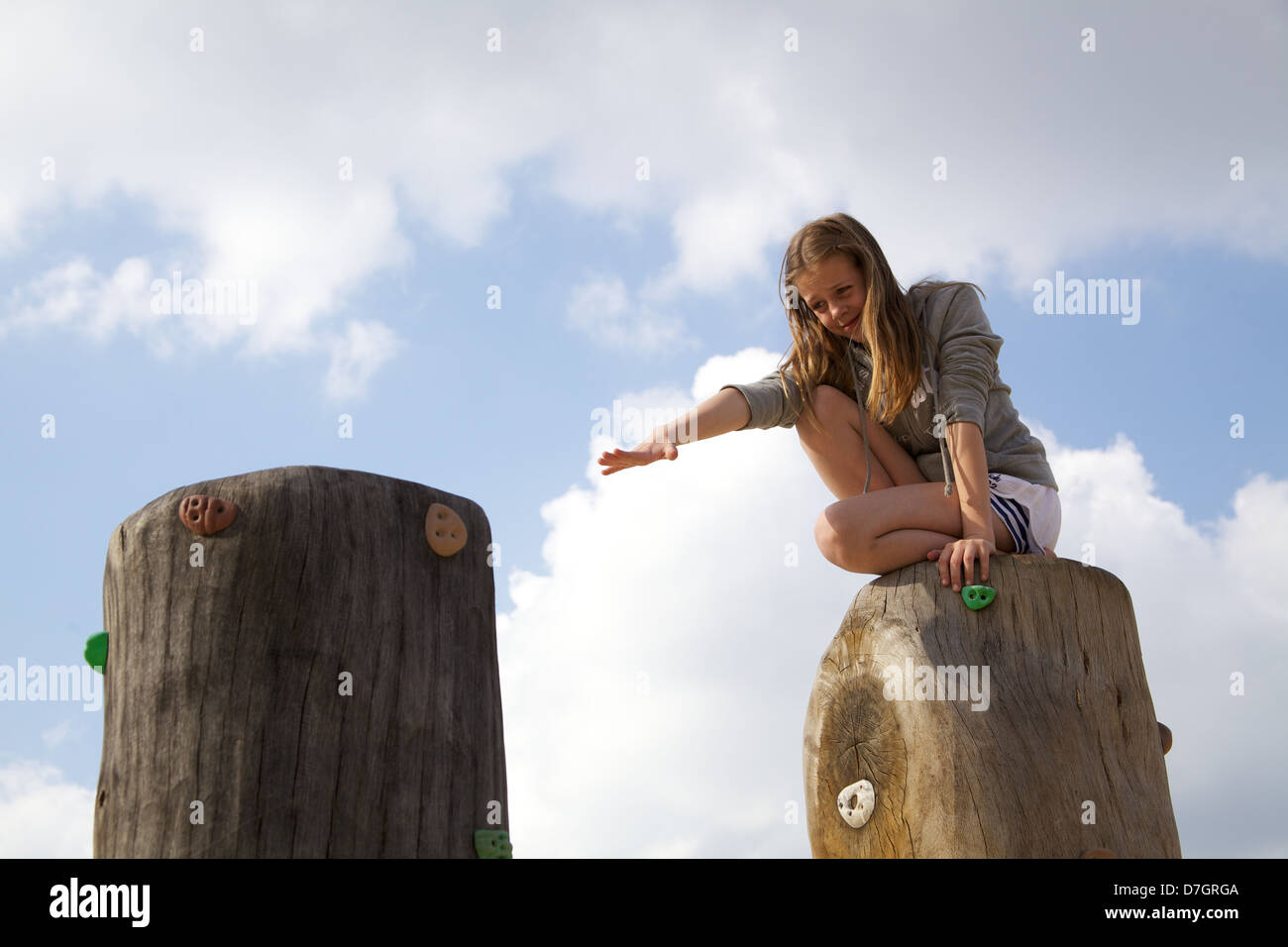 girl balancing on tree trunk attempting reach across a divide Stock ...