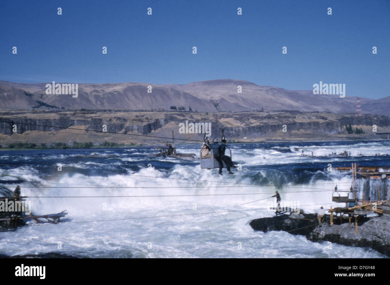 The image captures the traditional practice of fishing at Celilo Falls ...