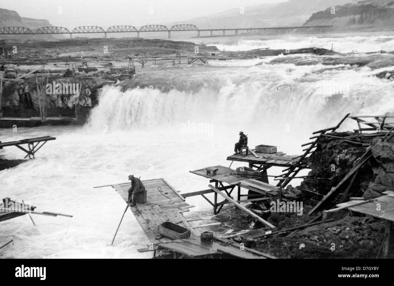 The photograph captures men fishing at Celilo Falls on the Columbia ...