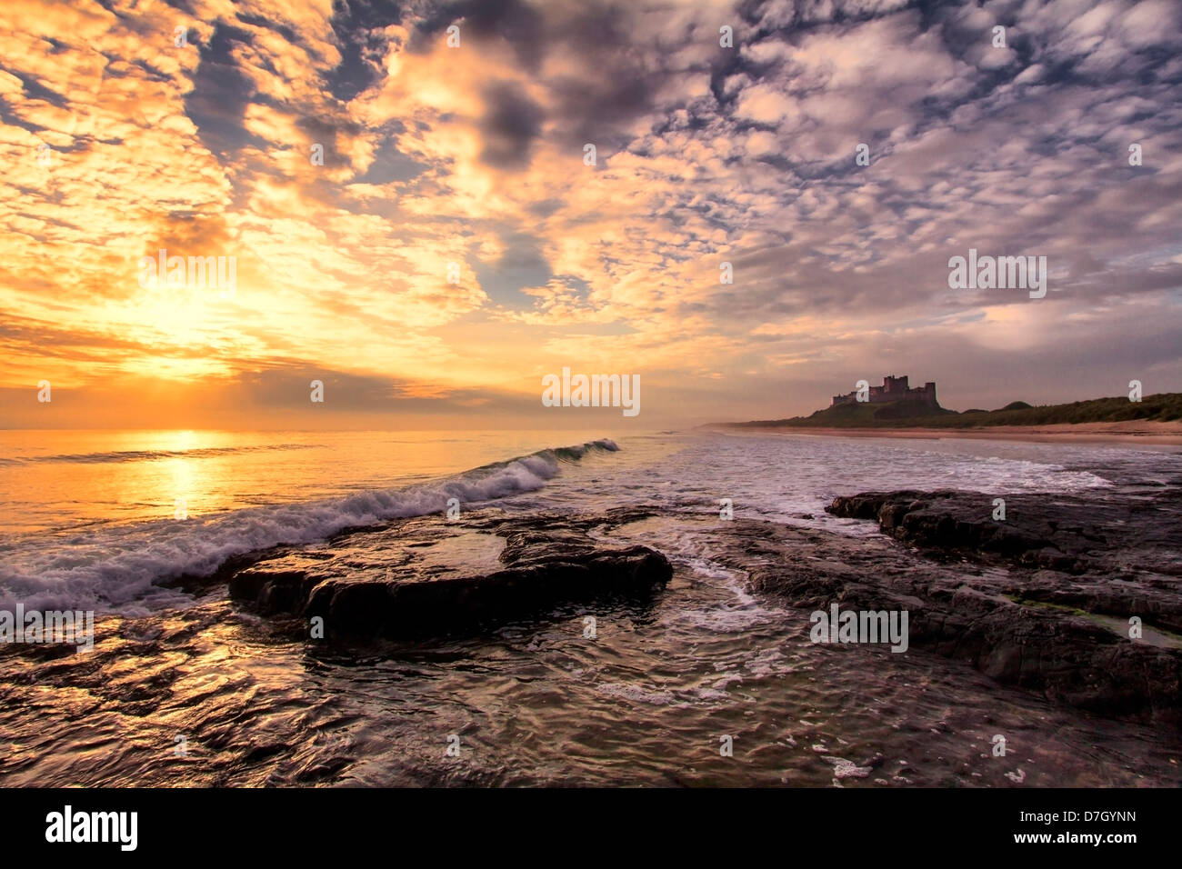 An image of the sun rising at Bamburgh castle Stock Photo - Alamy