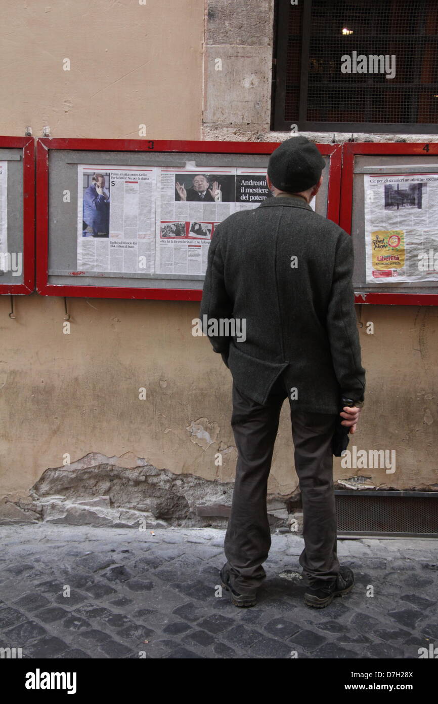 7 May 2013 Old man reading a newspaper article in street in Rome about ...