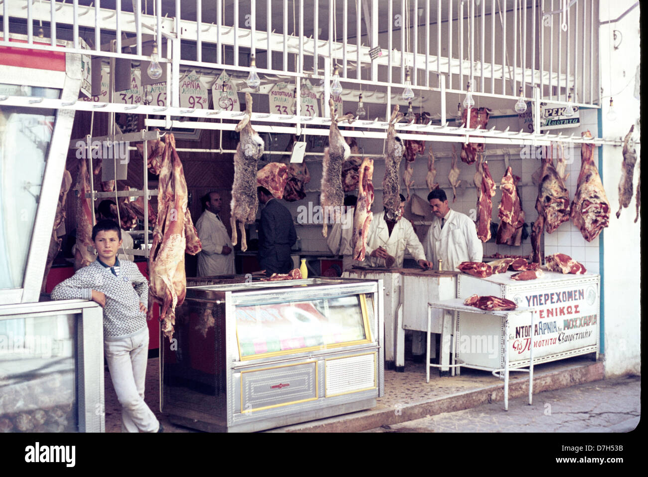 owners son stands in front of meat market also selling rabbits as ...