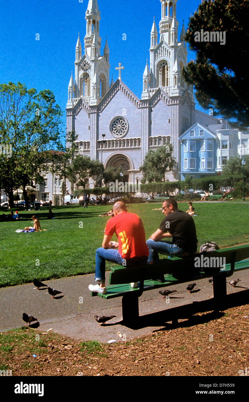 two friends talk while sitting on park bench in Washington square San ...