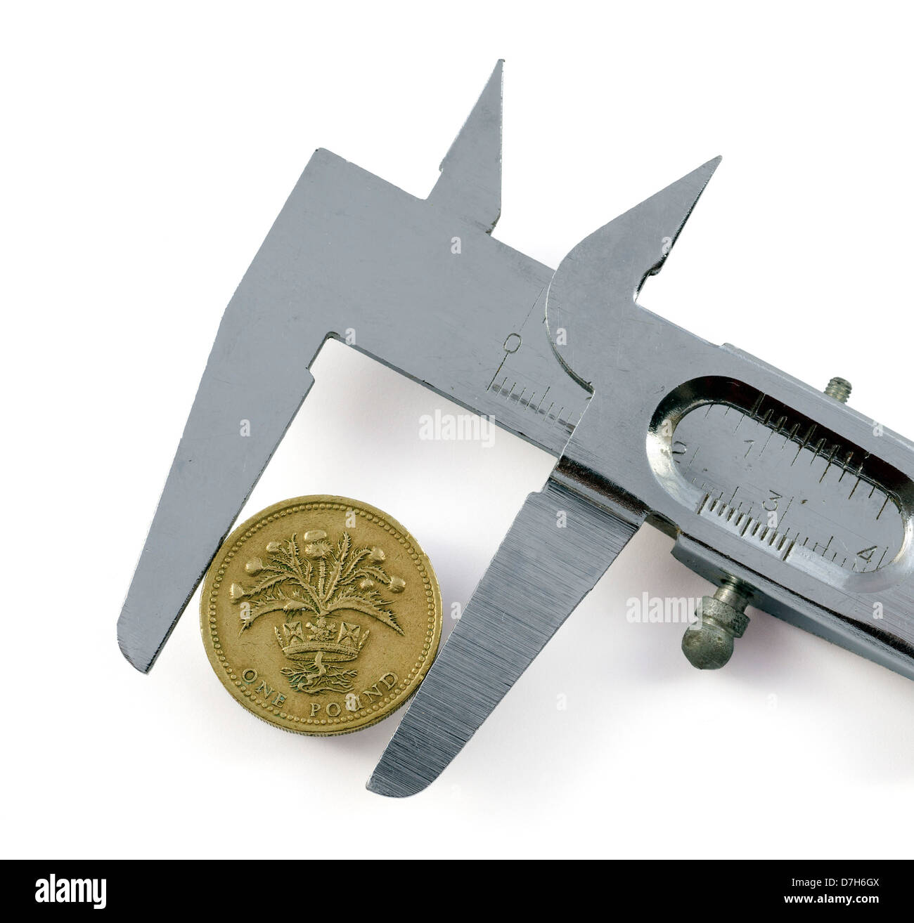 measuring a one pound coin with a caliper. Isolated image on white ...