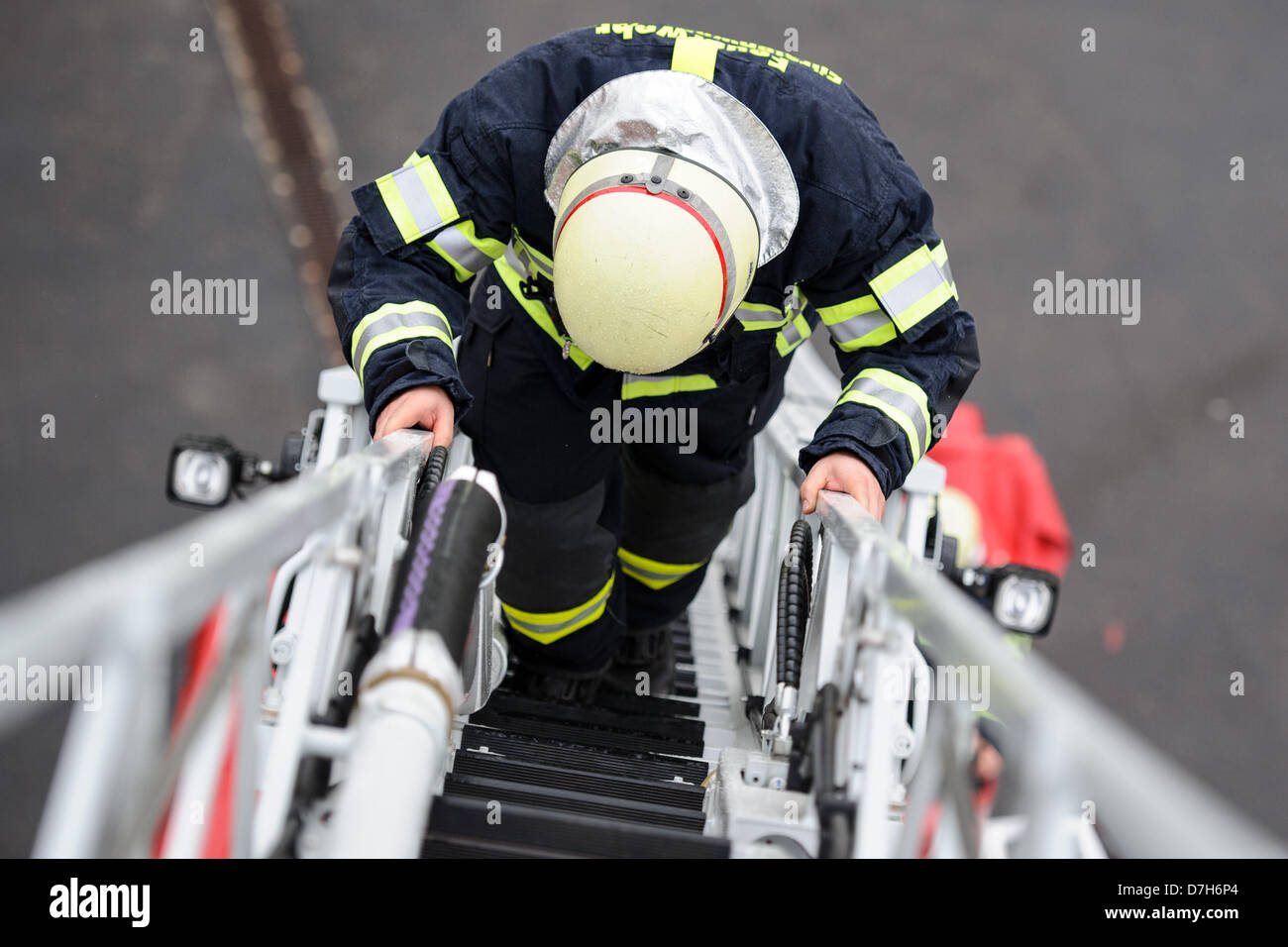 A firefighter climbs a ladder. Photo: Robert Schlesinger Stock Photo ...