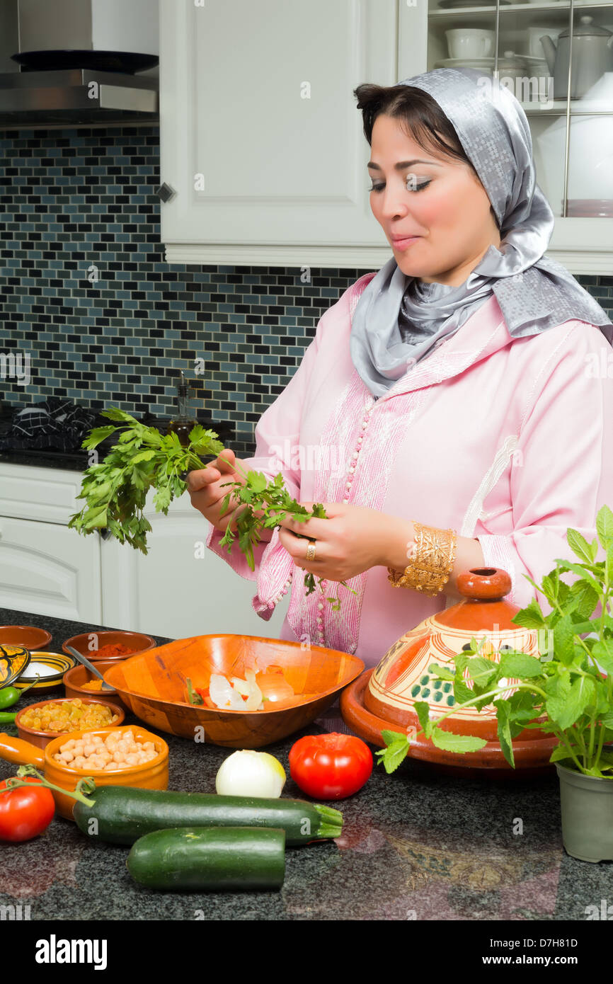 Traditional Moroccan immigrant woman in Europe cooking tajine during ...
