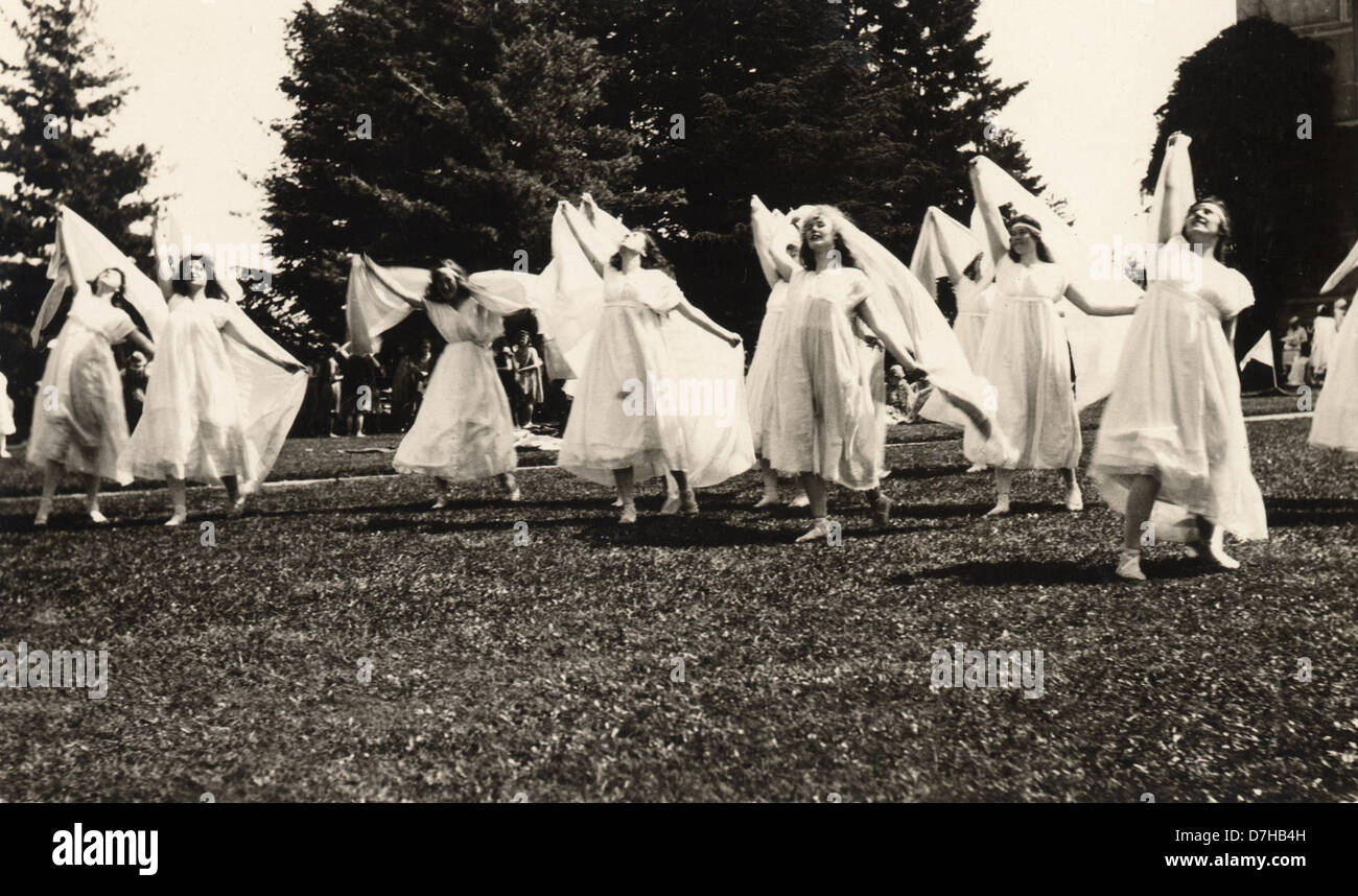 The image captures women dancing with veils at a May Day Pageant, an ...