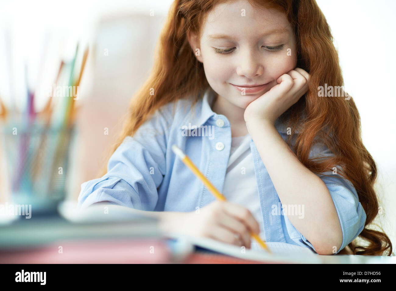 Cute little girl drawing at lesson and smiling Stock Photo - Alamy