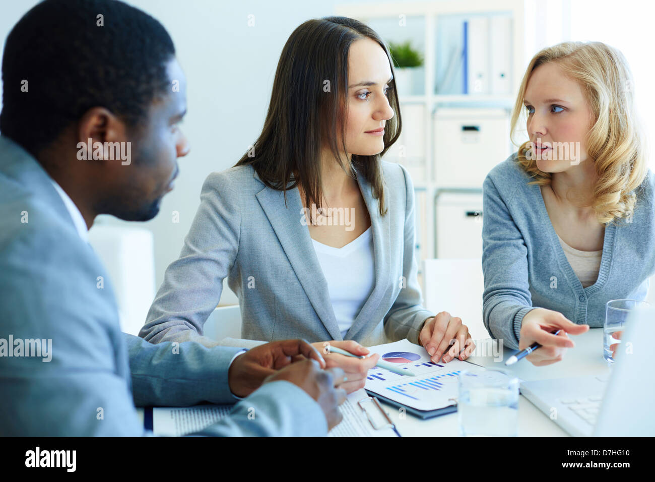 Three people discussing financial data hi-res stock photography and ...