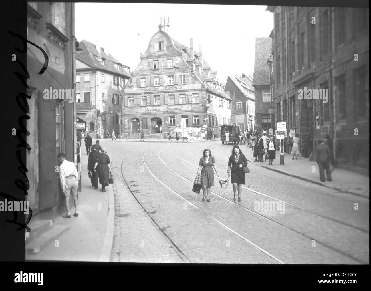The photograph captures a post-WWII street scene in Germany ...