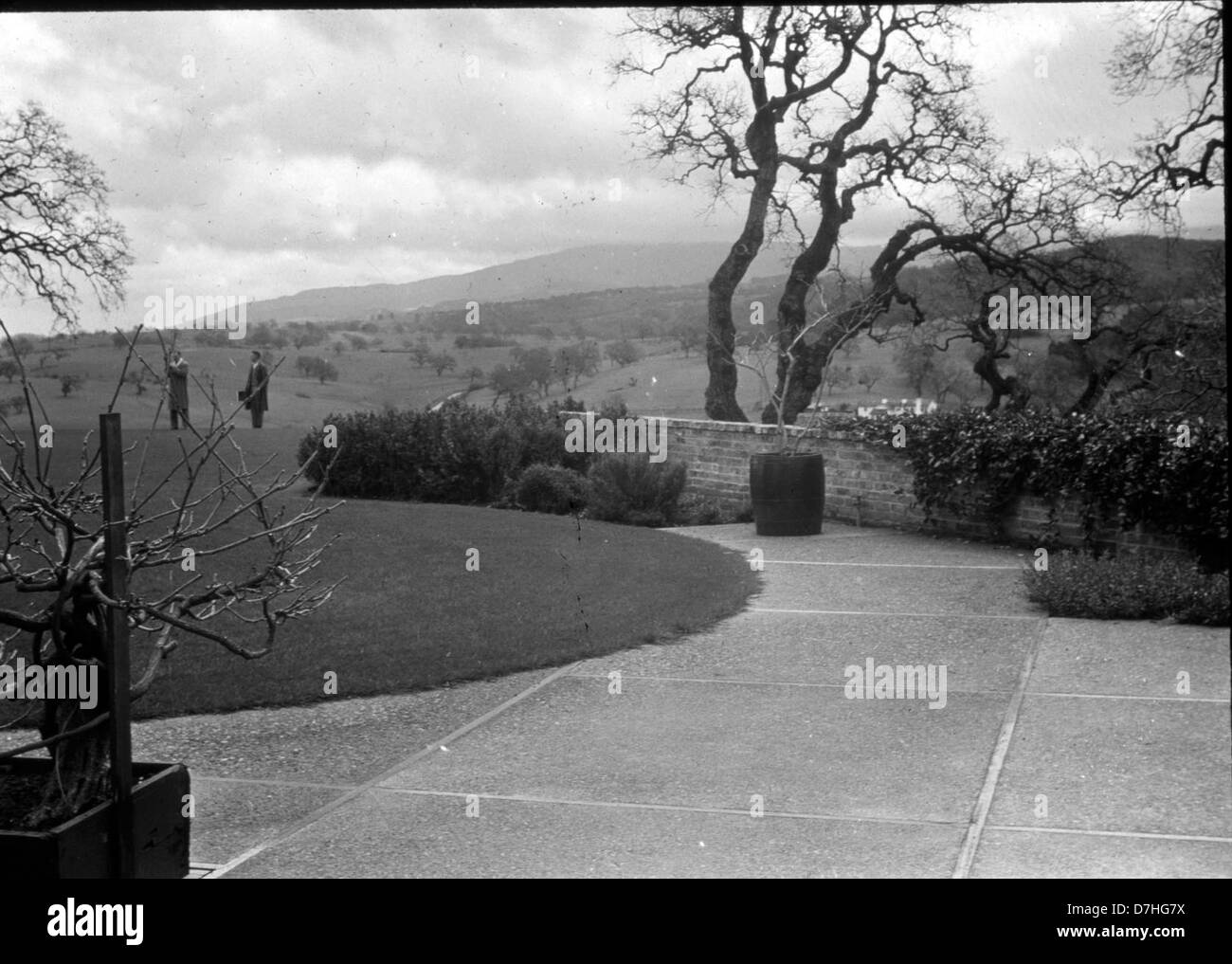 This image captures a vast, open landscape viewed from a lush lawn. The ...