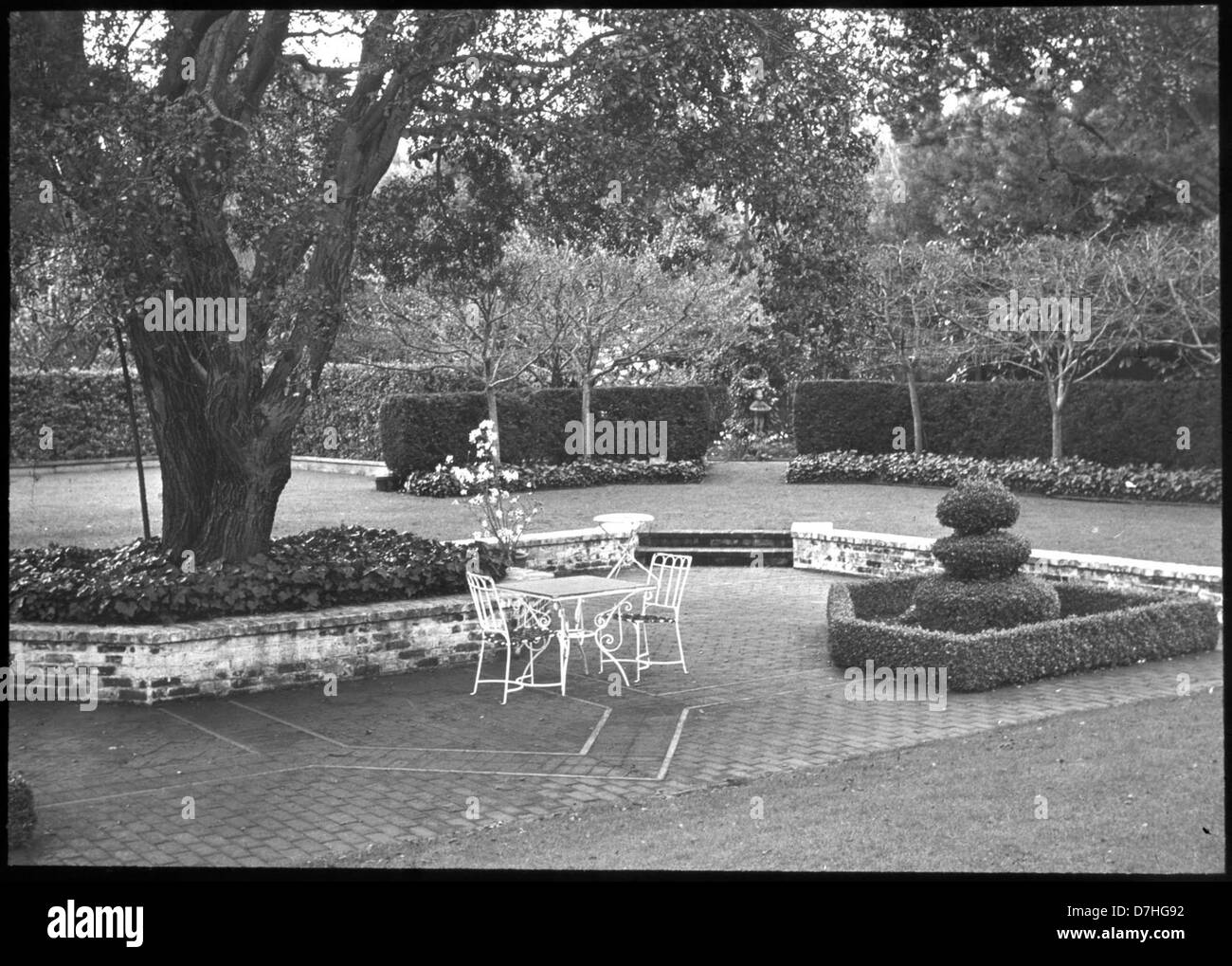 This image shows a well-maintained courtyard featuring topiary hedge ...