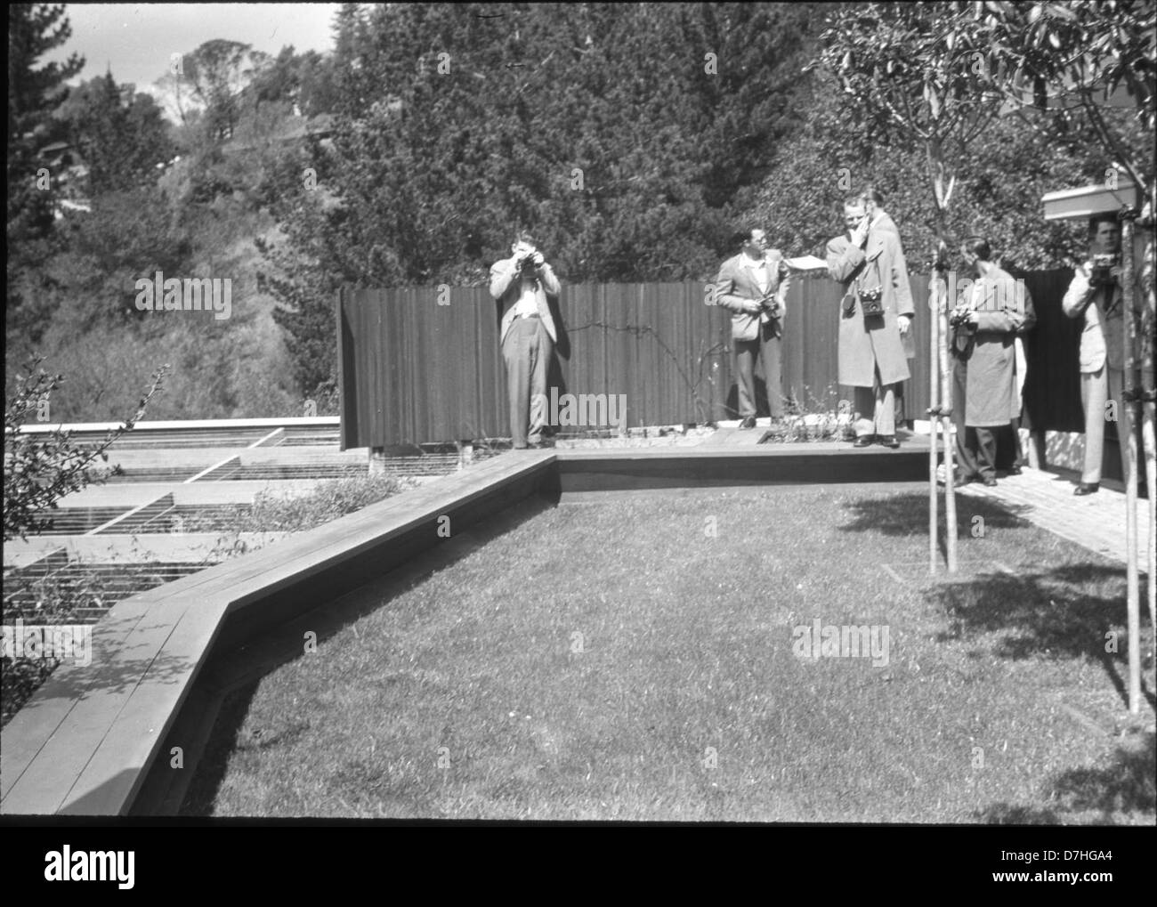 This image features photographers capturing scenes in a backyard with a ...