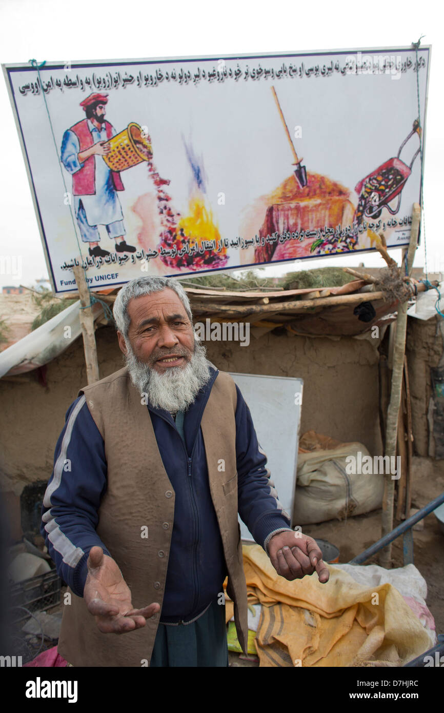 poor afghan refugee in front of an health information billboard, kabul ...