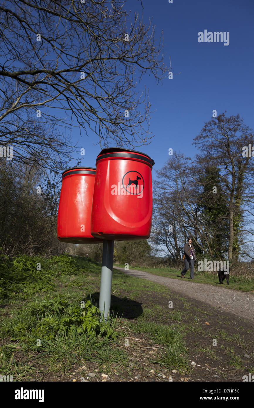 Red plastic dog poo waste bins on a footpath. For the disposal of dog ...