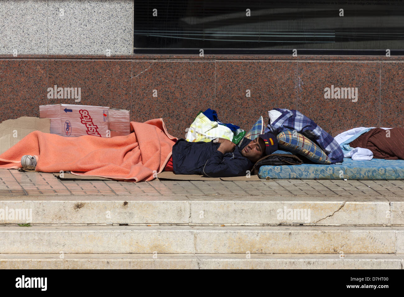 Man living rough, sleeping on pavement in Spain Stock Photo - Alamy