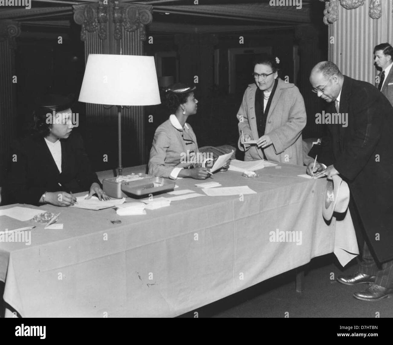 This historical photograph from 1955 shows the registration table at a ...