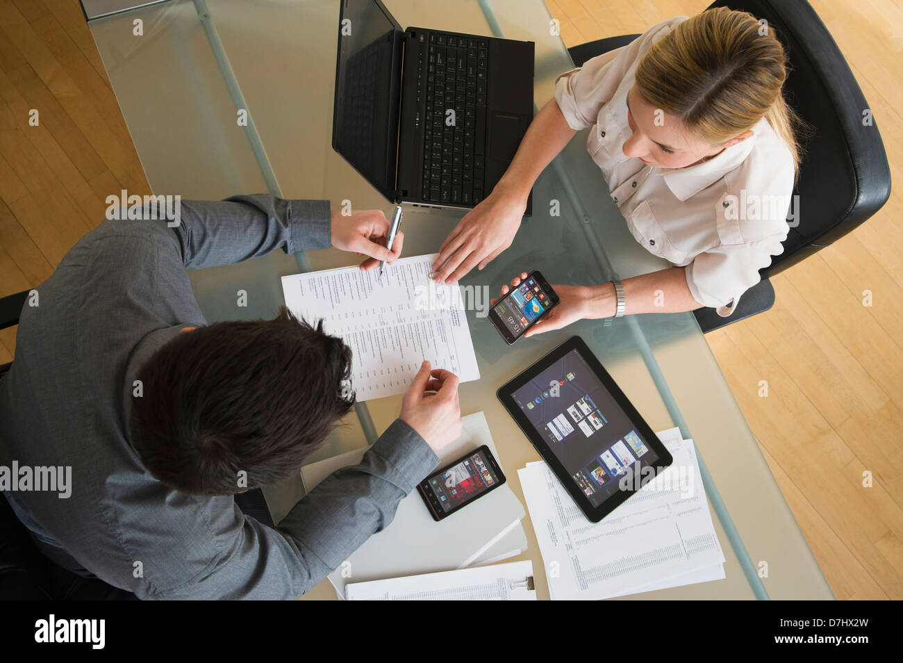 Young woman multiple devices office hi-res stock photography and images ...