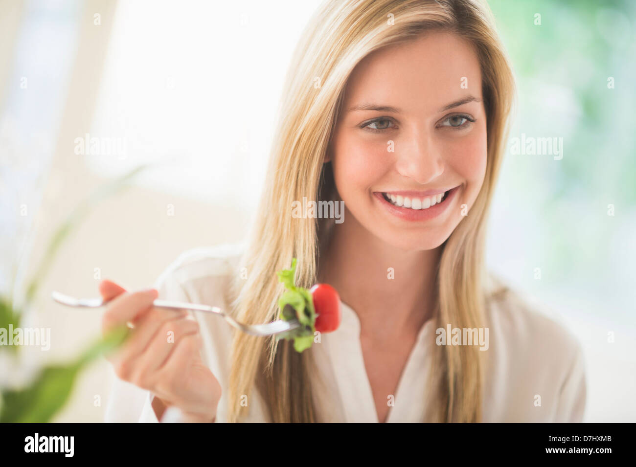 Woman eating and smiling Stock Photo - Alamy