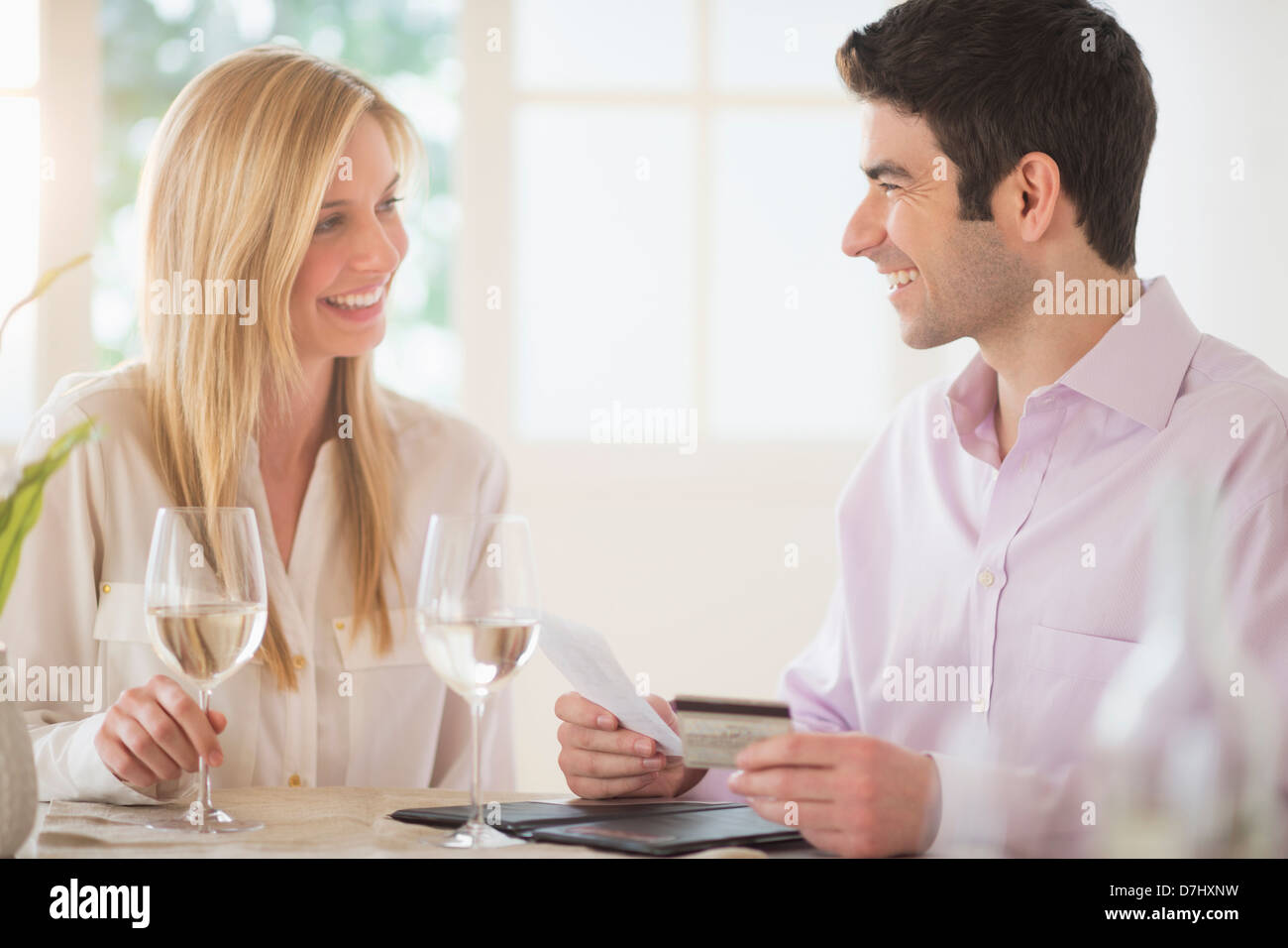Couple in restaurant, man paying Stock Photo - Alamy