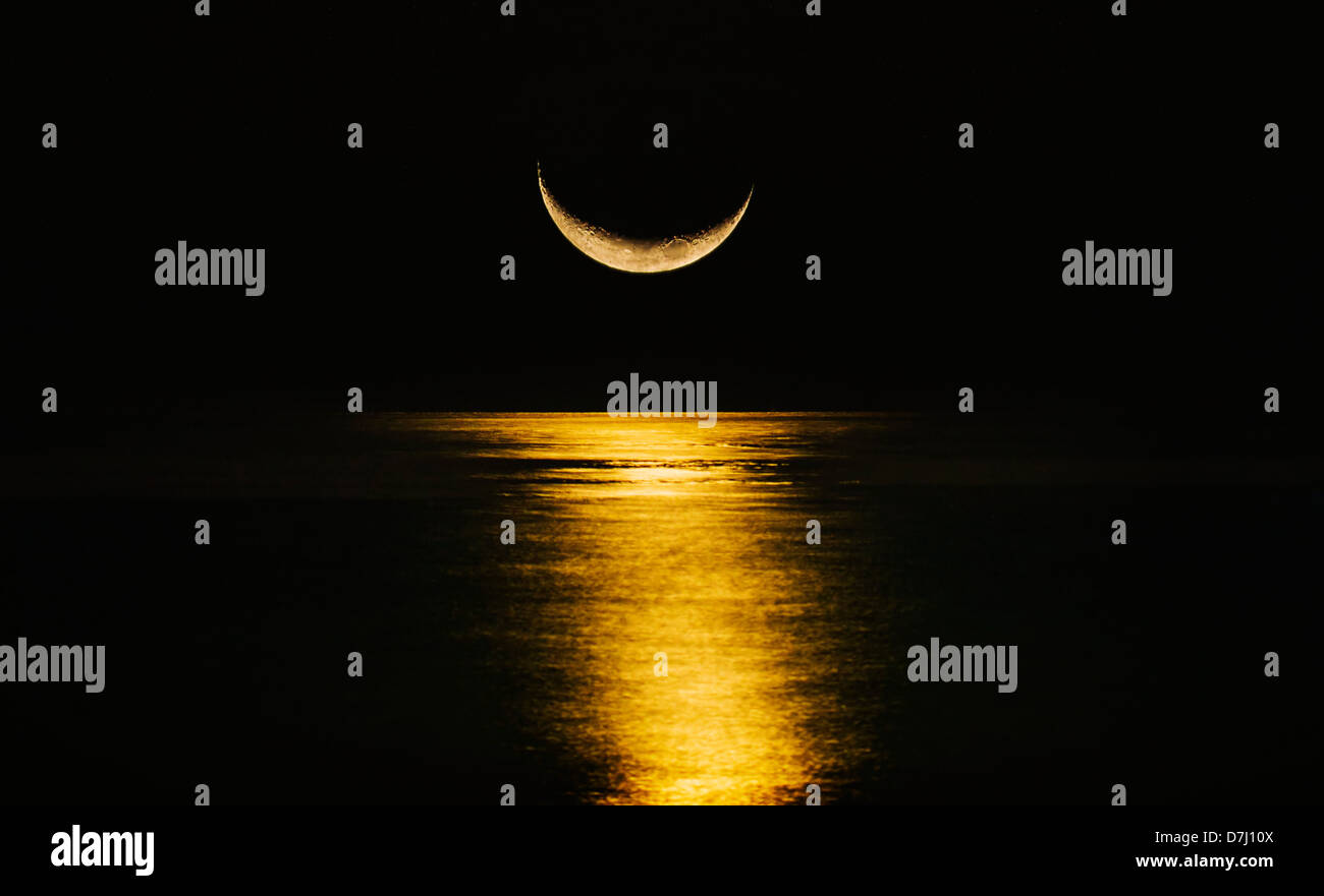 Crescent moon reflecting in sea Stock Photo - Alamy