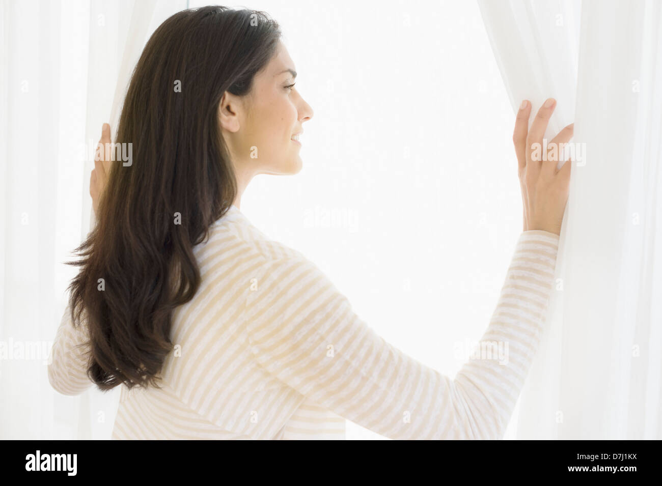 Woman looking through window Stock Photo - Alamy