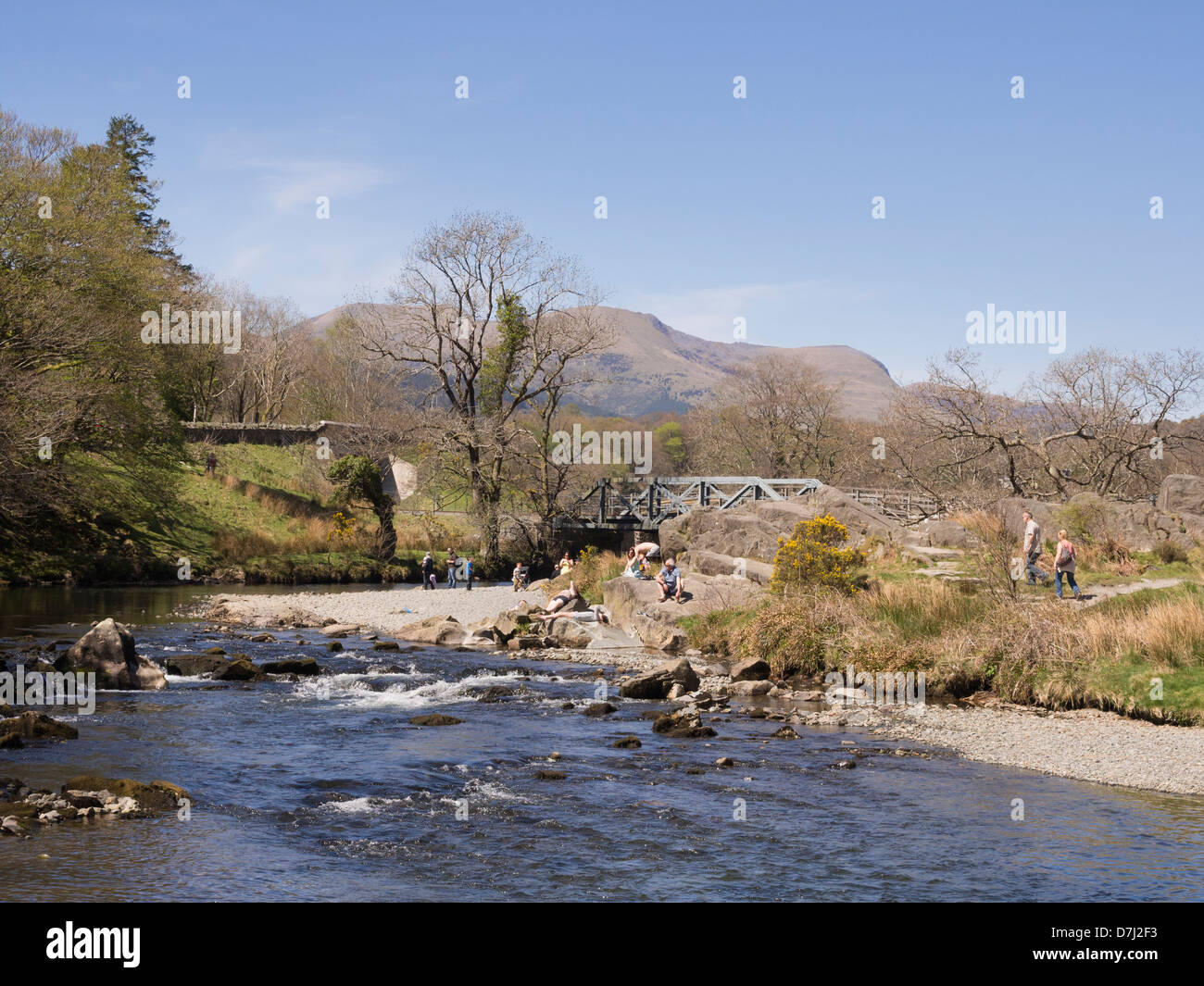 Tourists enjoying warm sunshine by Afon Glaslyn river in Aberglaslyn ...
