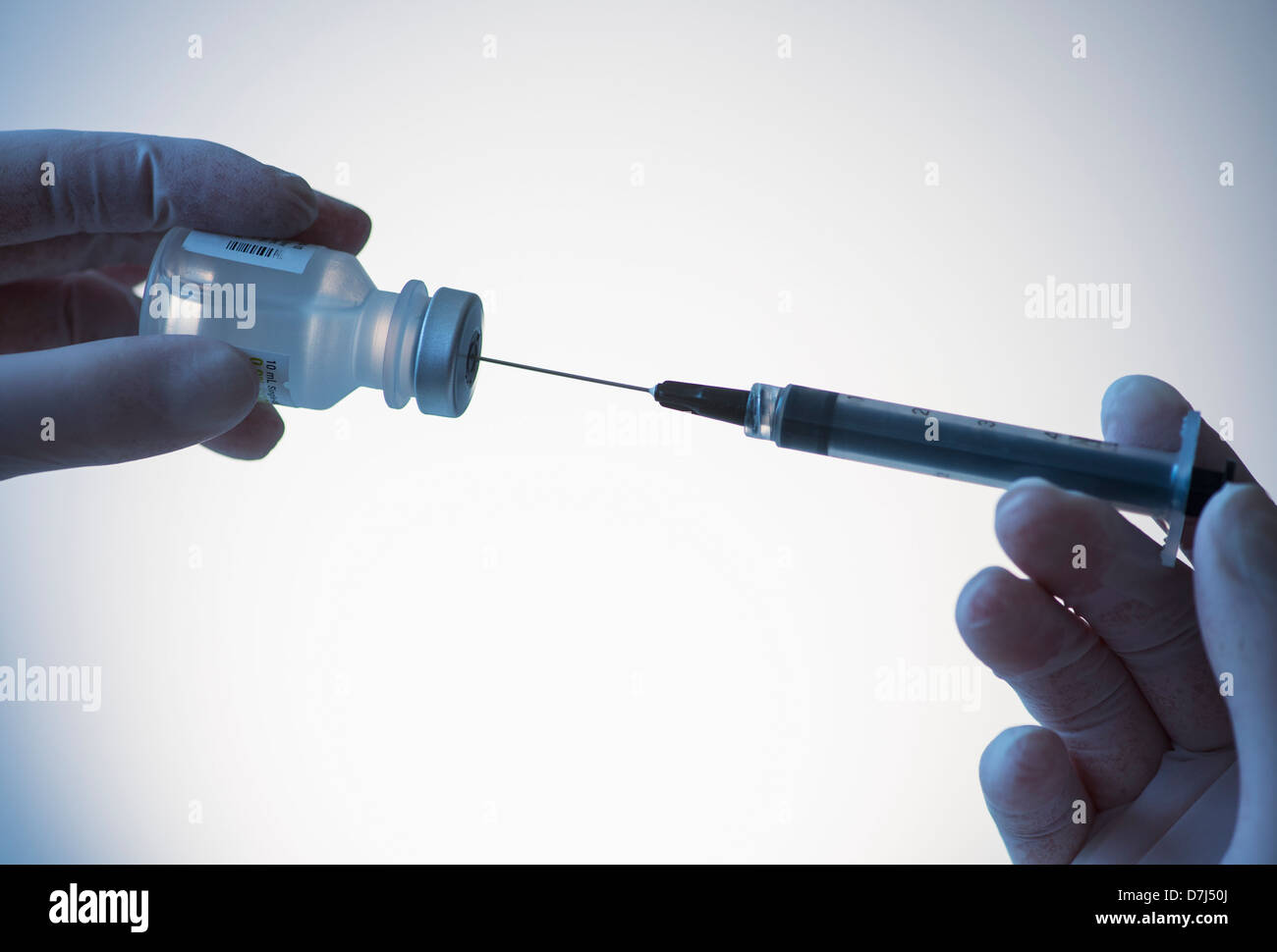 Close up of hands in surgical gloves preparing syringe for injection ...