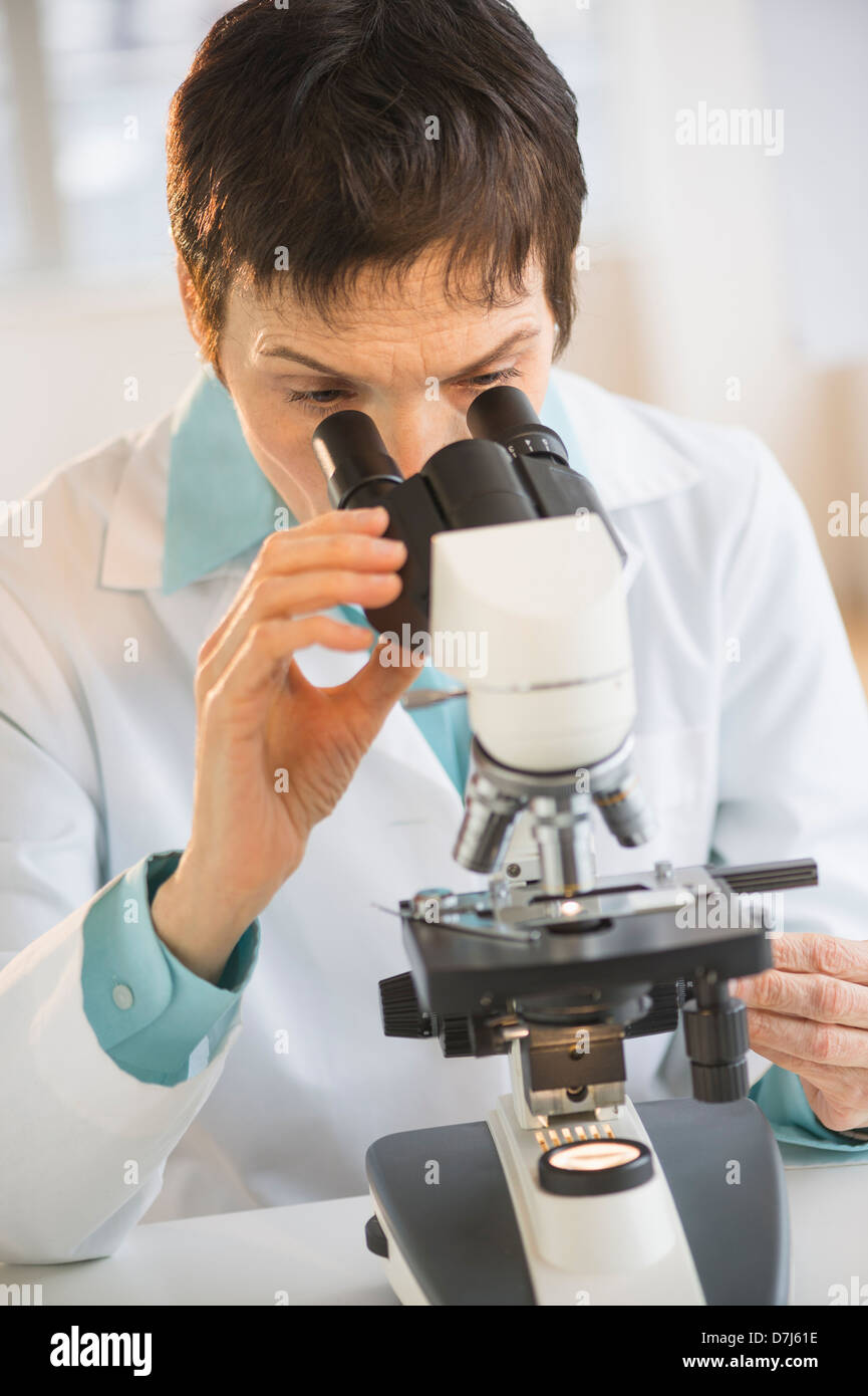 Mature scientist looking through microscope hi-res stock photography ...