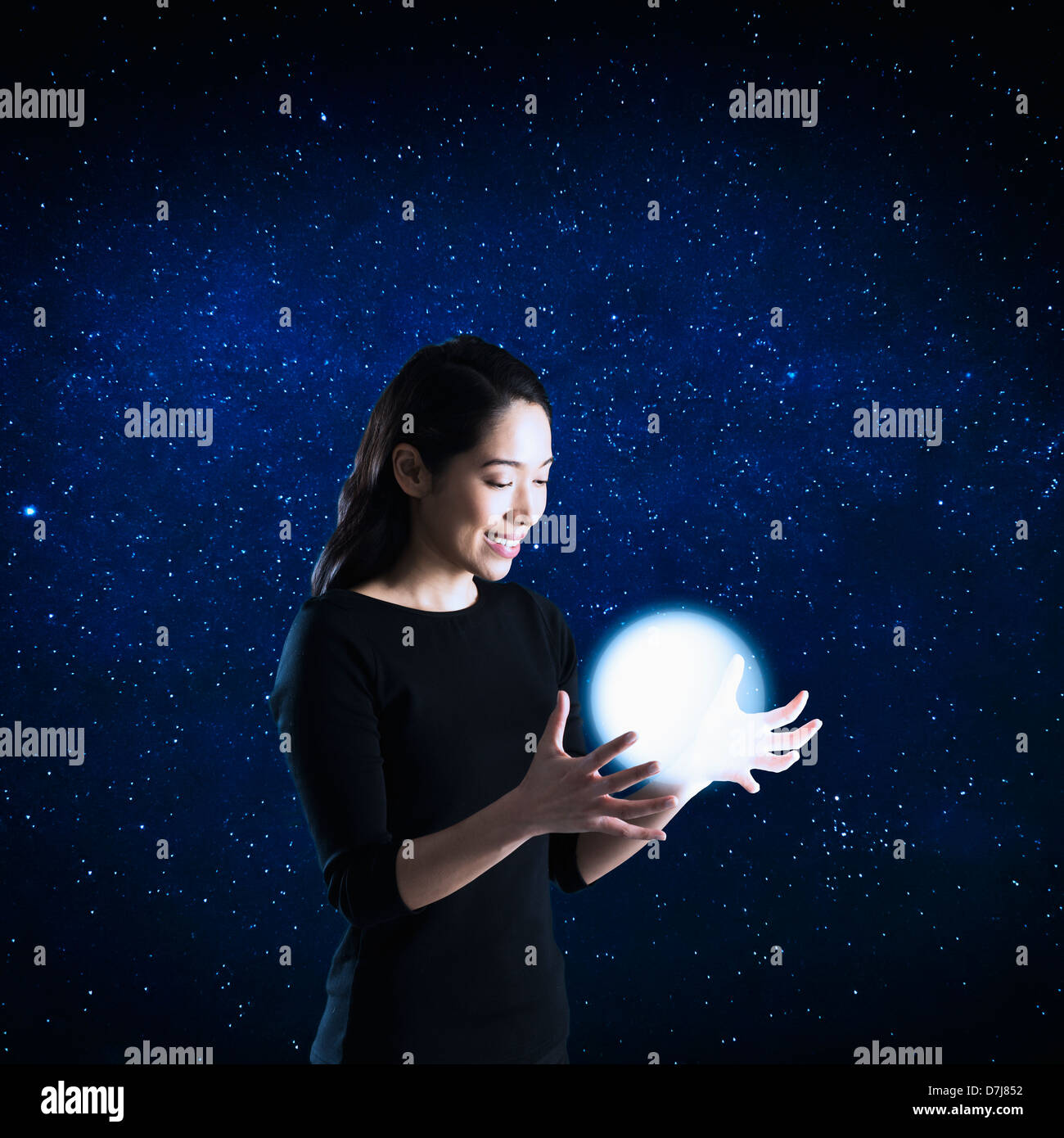 Woman catching glowing ball, studio shot Stock Photo - Alamy