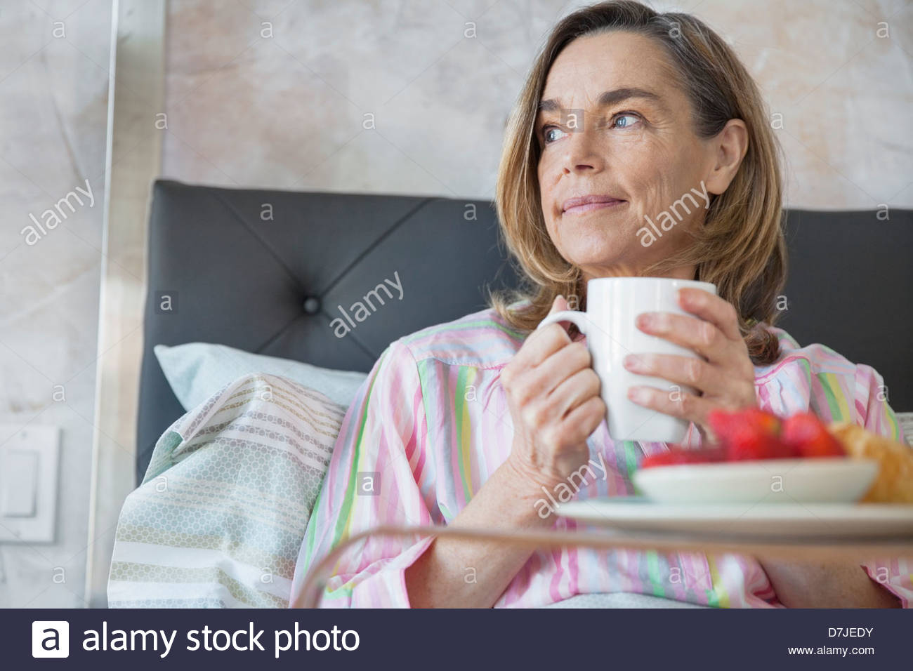 Woman eating in bed hi-res stock photography and images - Alamy