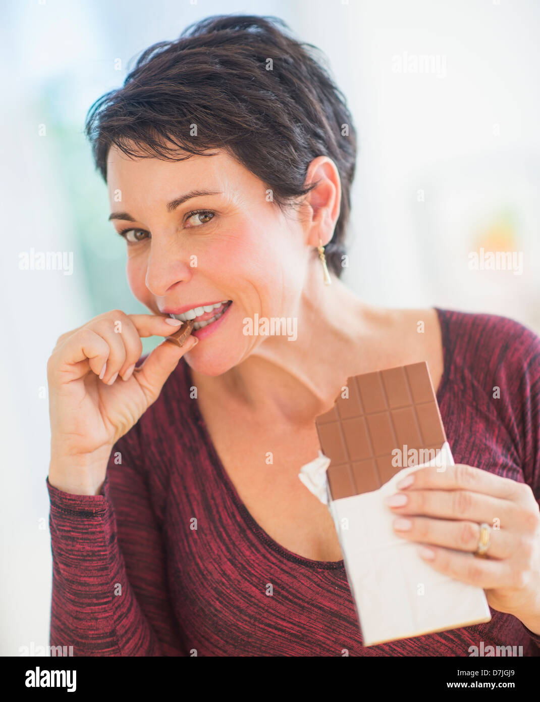 Portrait of mature woman eating chocolate Stock Photo - Alamy