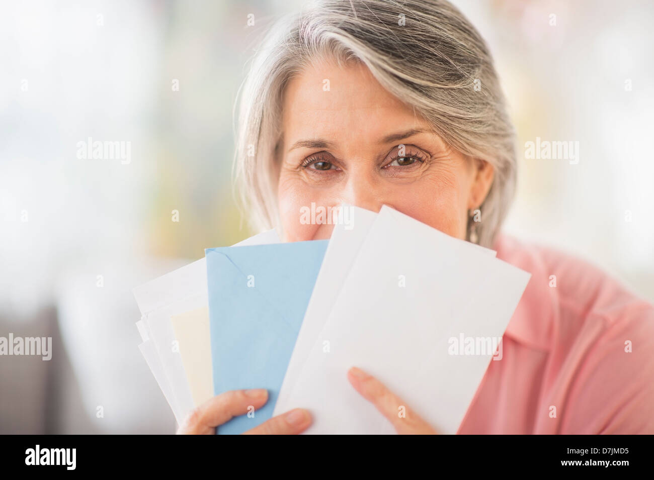 Portrait of woman holding mail Stock Photo - Alamy