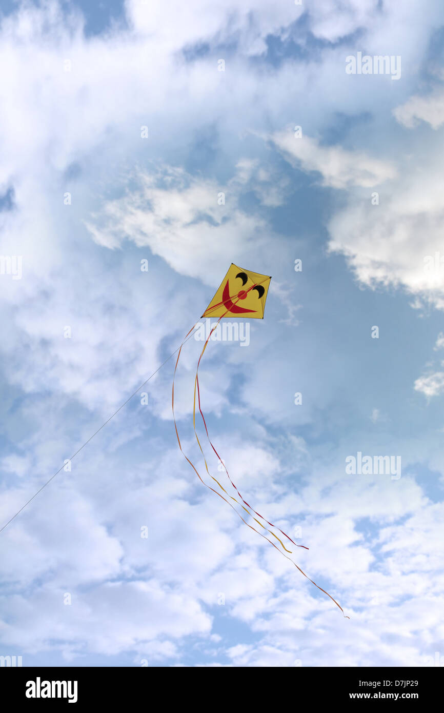 a smiley kite high in the cloudy blue sky Stock Photo - Alamy