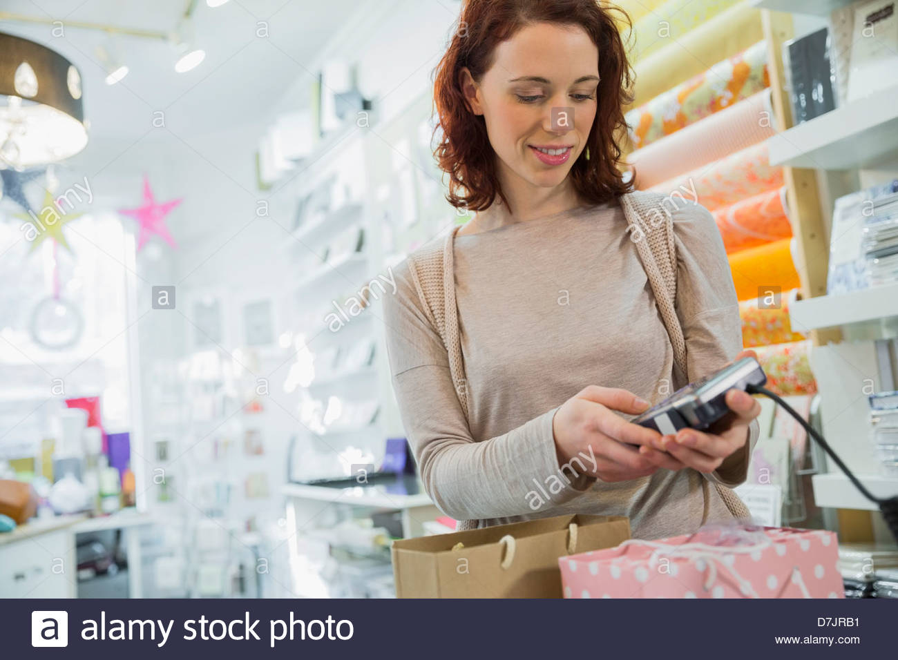 Female customer entering PIN into PIN pad at store Stock Photo - Alamy