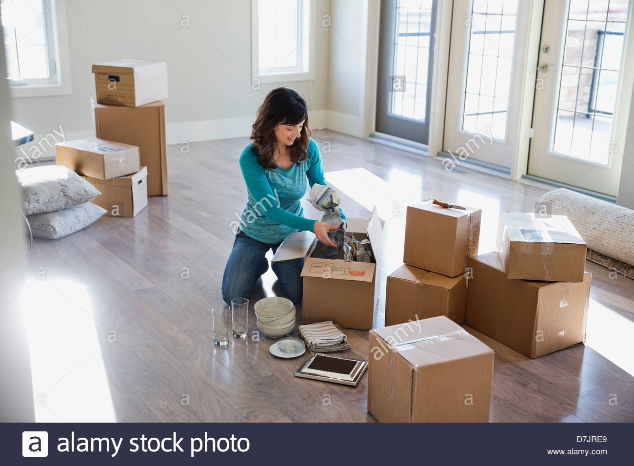 Woman unpacking cardboard boxes in new home Stock Photo - Alamy