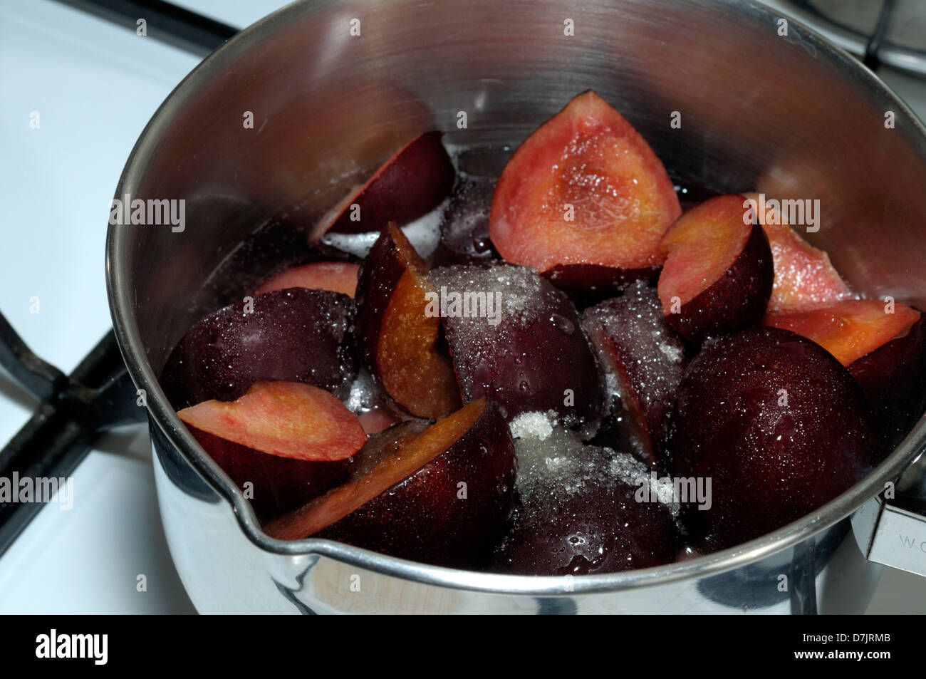 Organic Red Plums prepared in saucepan with sugar ready to be stewed ...