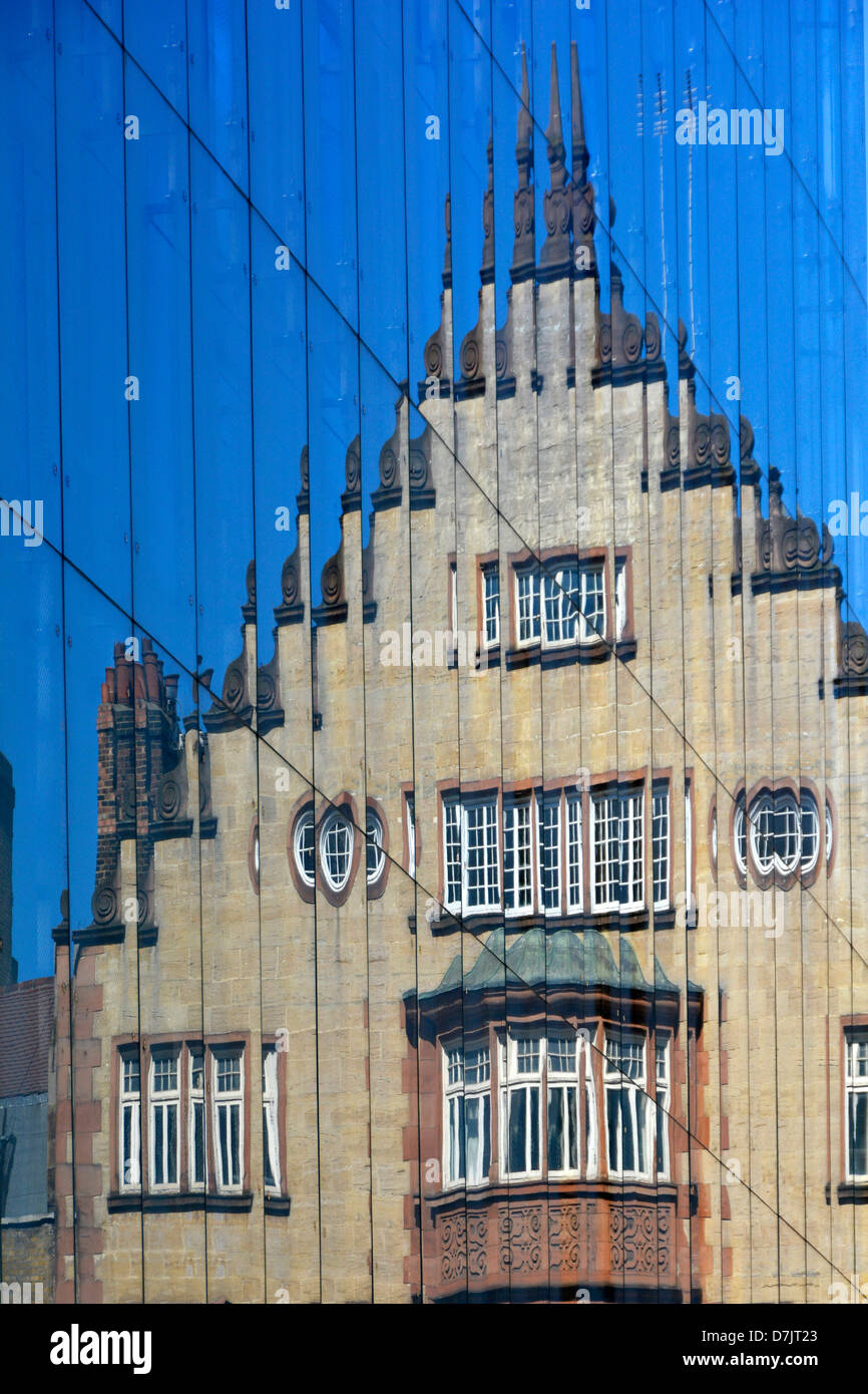 Reflection of old building in modern glass cladding to new office block ...