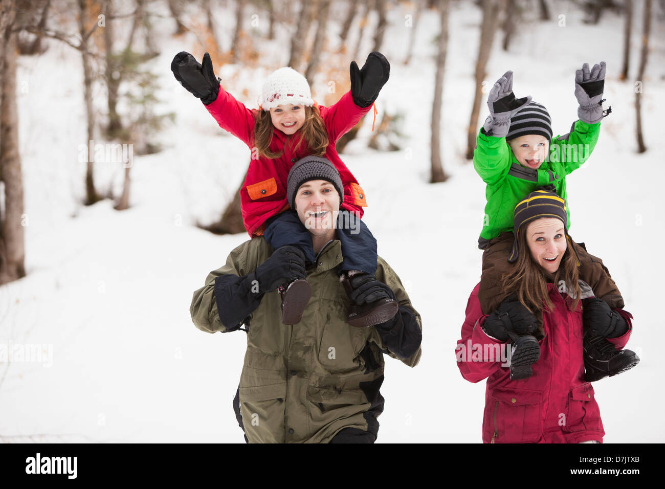 Parents carrying children on shoulders fun outdoors hi-res stock ...