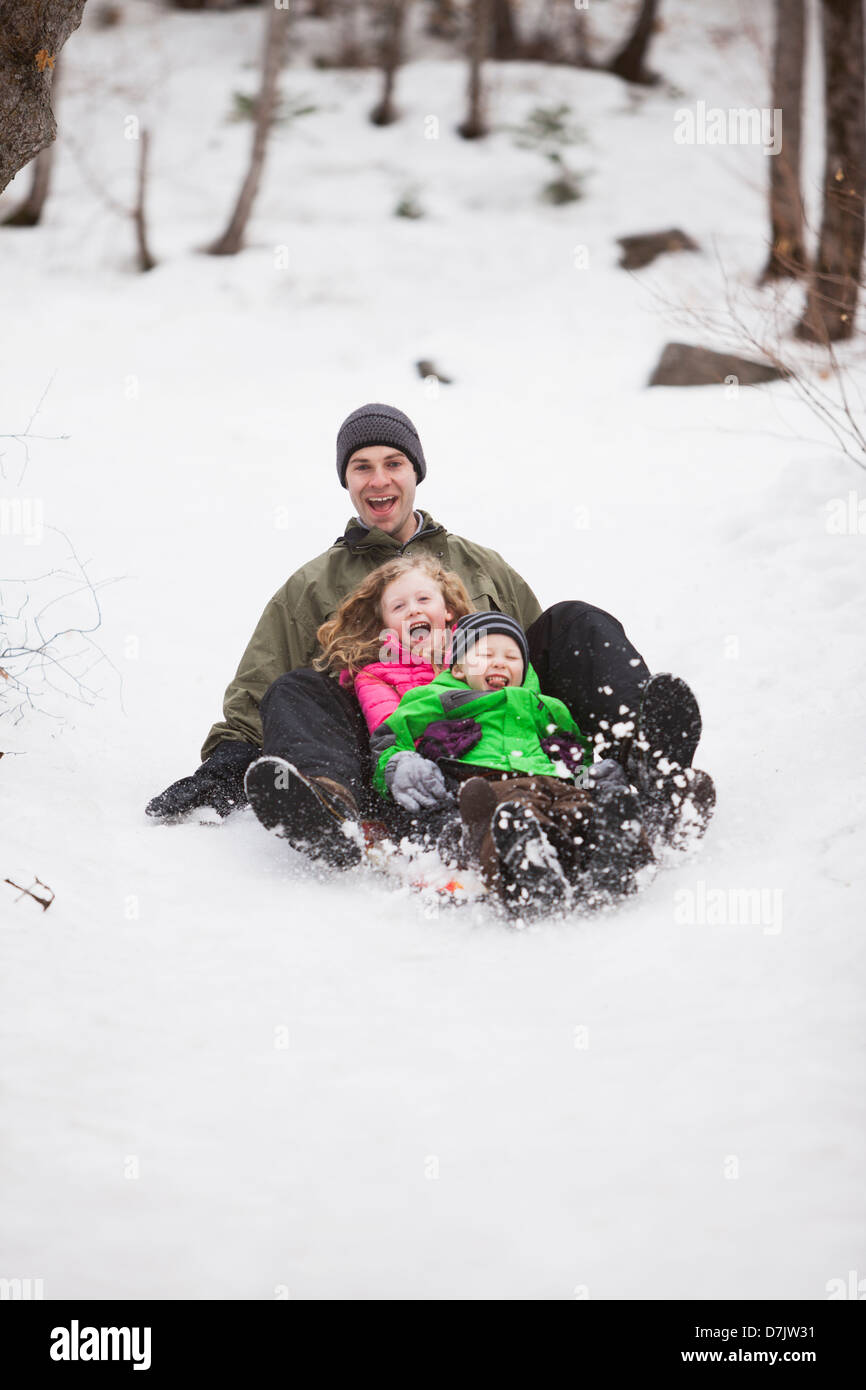 Portrait of young man sledding with children (4-5 Stock Photo - Alamy