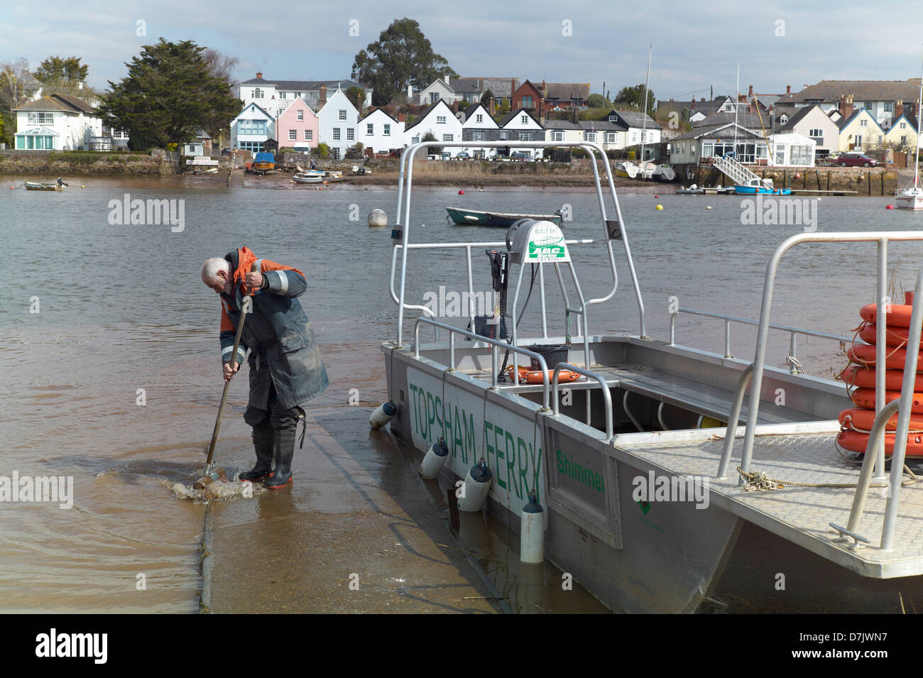 Ferryman cleaning the slipway of the Topsham ferry river exe exeter ...