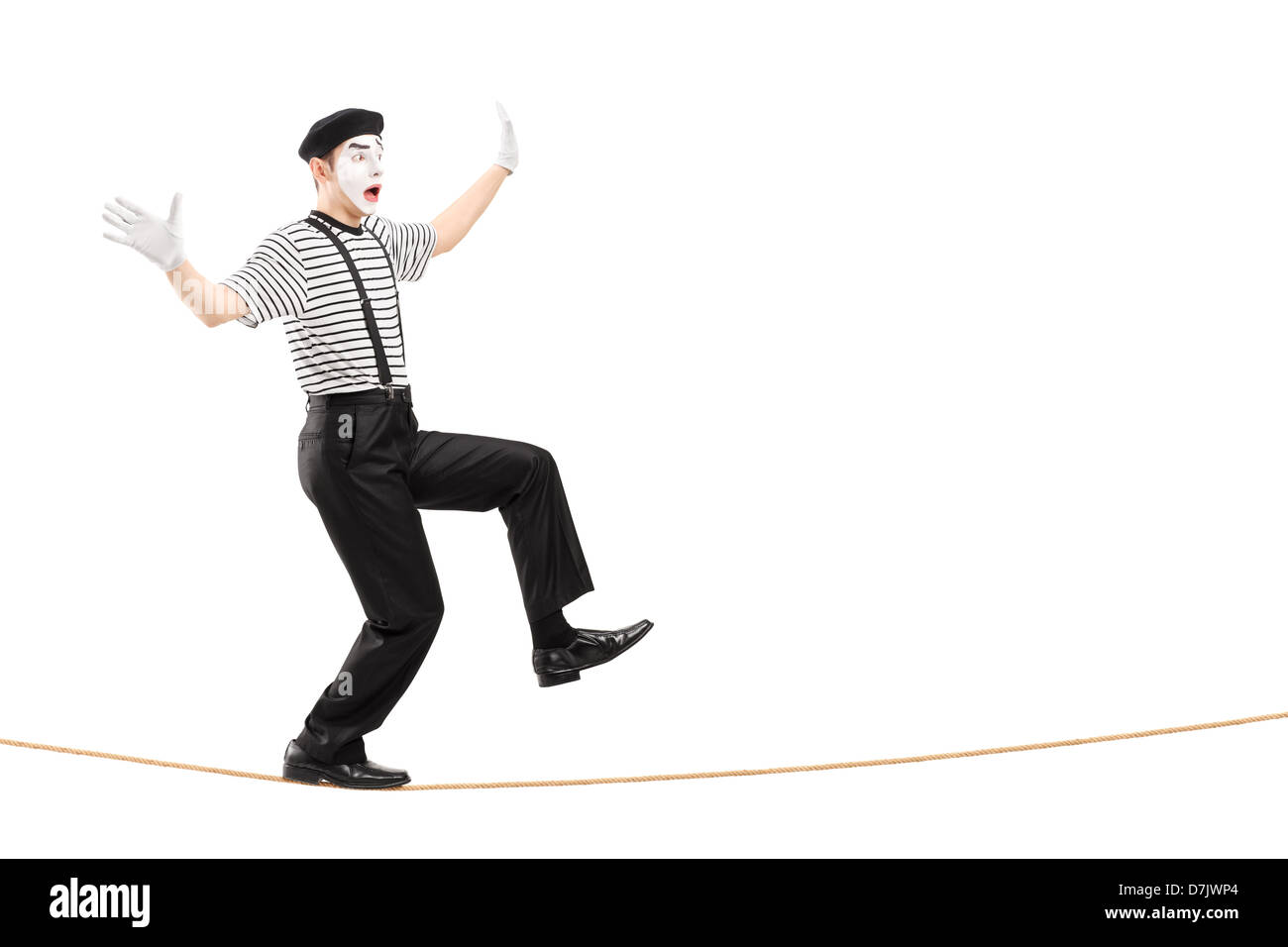 Full length portrait of an excited male mime artist walking on a rope ...